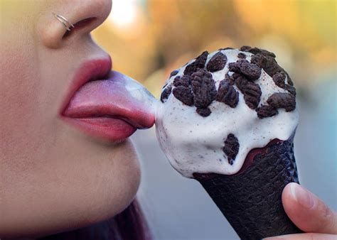 Girl Sensually Licks Oreo Ice Cream With The Tip Of Her Tongue Outdoors