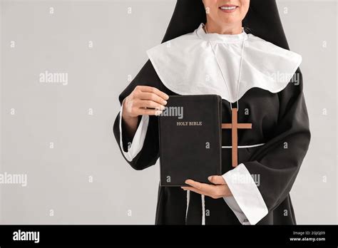 Mature Nun With Holy Bible On Light Background Stock Photo Alamy