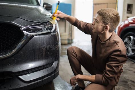 Side View Of Caucasian Man Worker Of Car Wash Service Cleaning