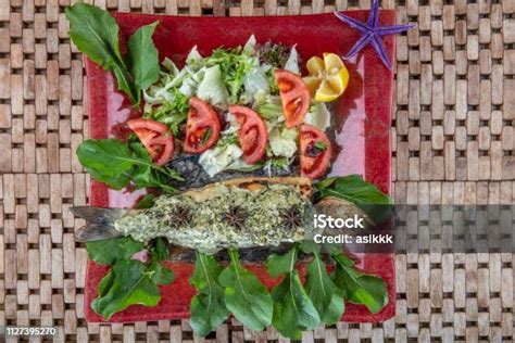 Bass Laut Panggang Disajikan Di Atas Piring Dengan Berbagai Saus Dan