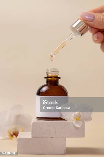 흰색 난초 꽃 근처의 열린 화장품 점적기 병 위에 피펫을 든 손 Mockup 라벨 갈색에 대한 스톡 사진 및 기타 이미지 갈색 건강관리와 의술 건강한 생활방식