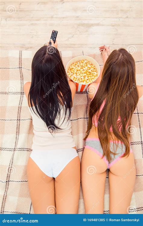 Top View Of Two Young Women Watching Tv With Popcorn Stock Image