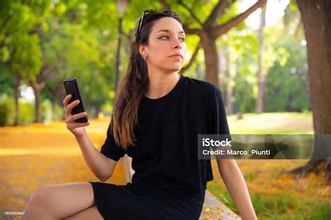 도시 공원에서 야외에서 스마트 폰을 사용하는 젊은 여성 20 29세에 대한 스톡 사진 및 기타 이미지 20 29세