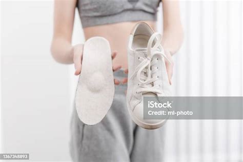정형 외과 깔창과 운동화를 가진 스포츠웨어의 피트니스 여성 집에서 신발에 정형 외과 깔창을 넣어 여자 클로즈업 풋 케어 배너