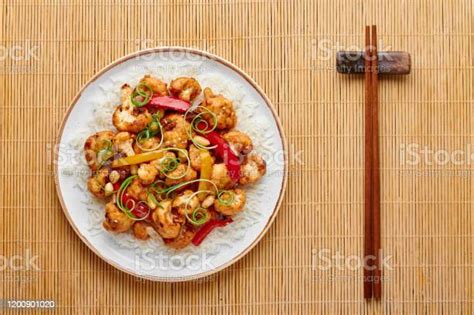 어두운 슬레이트 배경에 쿵 파오 콜리플라워 쓰촨 쿵파오 콜리플라워는 고추 땅콩 소스 양파를 곁들인 중국 요리 채식 요리입니다 맨