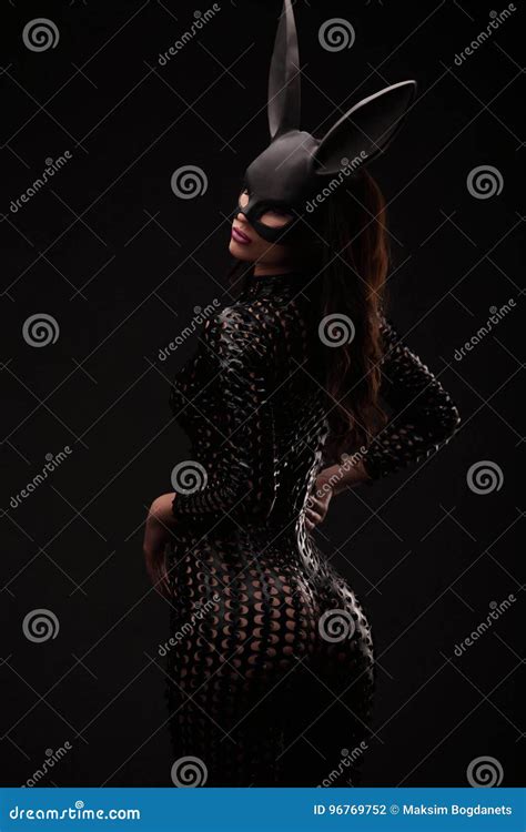 Ritratto Della Donna Castana Sexy Che Posa Nella Maschera Del Nero Del