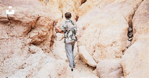 흰색 티셔츠와 파란색 데님 청바지를 입은 남자가 낮에 갈색 바위 위에 서 있다 사진 Unsplash의 무료 베이지색의 이미지