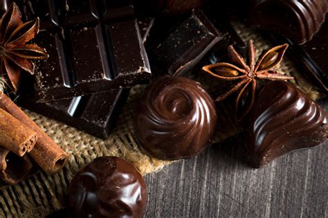 ダークホワイトミルク チョコレートのスタックチップの品揃え素朴な木製の解任の背景にチョコレートとコーヒー豆スパイスシナモン選択マクロ