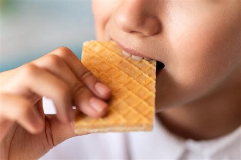 Premium Photo Close Up An Unrecognizable Woman Bite Waffle Sweet Dessert