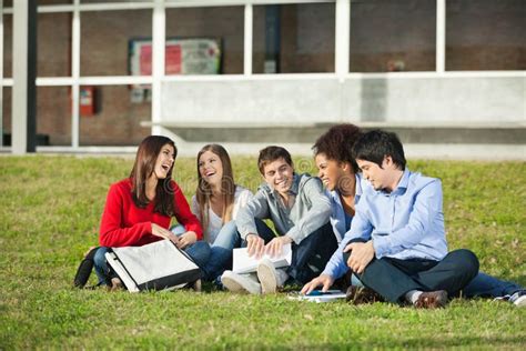 Étudiants S asseyant Ensemble Sur L herbe à L université Image stock Image du asiatique