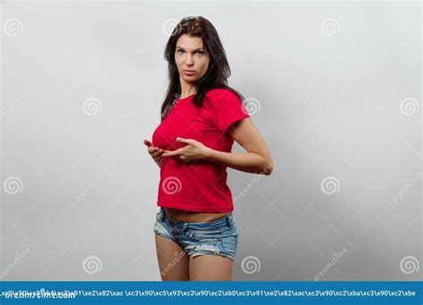 Young Beautiful Girl Stands Holding Her Breasts With Her Hands