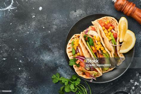 구운 닭고기 아보카도 옥수수 커널 토마토 양파 실란트로 살사를 곁들인 멕시코 타코 전통적인 멕시코 와 라틴 아메리카 길거리 음식