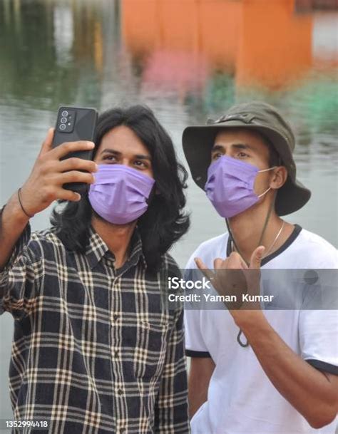 코로나바이러스 전염병 중 호수 옆에서 얼굴 마스크를 쓰고 셀카를 찍는 두 친구 20 29세에 대한 스톡 사진 및 기타 이미지 20 29세 2명 Brand Name