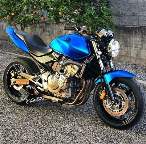 A Blue And Black Motorcycle Parked In Front Of A Tree With Oranges