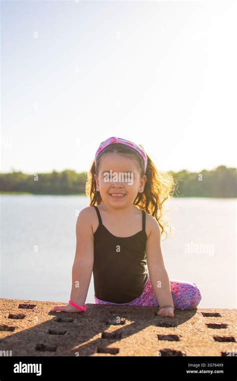 A Cute Spanish Girl Happily Standing On The Riverside With The River On