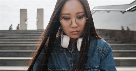 안경과 헤드폰을 쓴 아시아 소녀는 노트북 화면을 단호하게 바라본다 사진 Unsplash의 의류 이미지