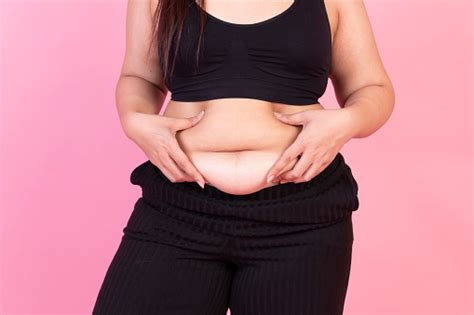 뚱뚱한 여자는 그녀의 뚱뚱한 배를 가지고 노는 분홍색 배경에 서 행복 과체중 여자 뚱뚱한 뚱뚱한 여자 플러스 크기 패션 모델 핑크 배경에 뚱뚱한 여자 25 29세에 대한