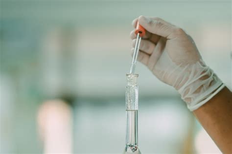 실험실 연구 개념 학생을 위한 교실의 테스트 화학 실험실 물방울로 비커에 핸드 드롭 화학 용액을 닫고 화학 실험실에서 학습을