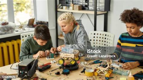 솔루션을 제공합니다 로봇 수업에서 로봇과 차량을 만드는 세 명의 아이들 똑똑한 아이들과 Stem 교육 과학에 대한 스톡 사진 및
