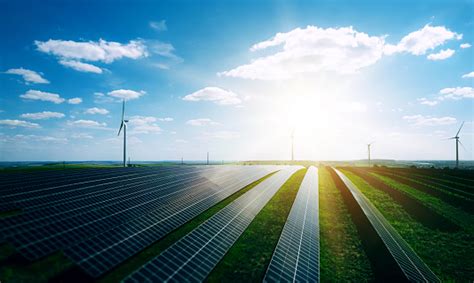 녹색 에너지는 탄소 배출량을 줄이고 지구를 더 깨끗하고 생태적으로 만듭니다 화창한 날에는 태양 전지판이 주차하고 풍력 터빈이 있습니다 녹색 에너지를 전기로 생산하는 풍차