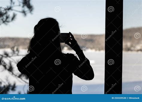 Silueta De Una Mujer Tomando Una Foto Del Lago Congelado En Quebec