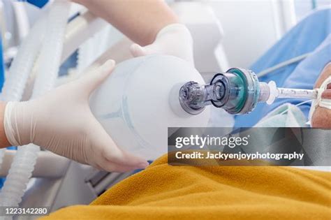Doctor Holding Oxygen Ambu Bag Over Patient Given Oxygen To Patient By