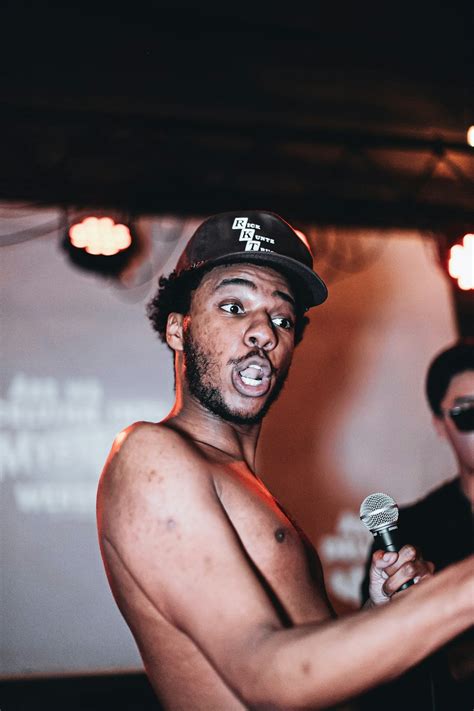 Homme Aux Seins Nus Portant Une Casquette Noire Tenant Un Microphone