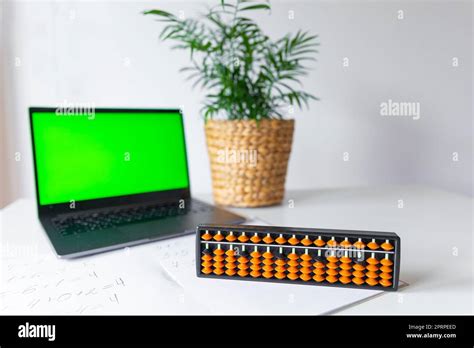 Abacus For Mental Arithmetic On A Table With A Laptop Chroma Key Background For Insertion