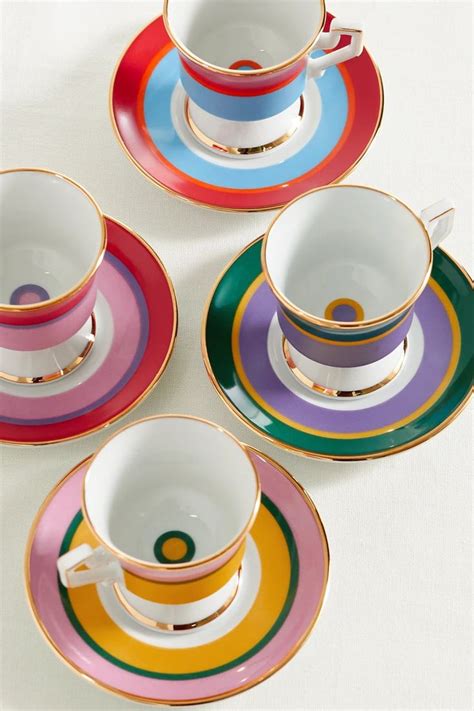Four Colorful Cups And Saucers On A White Table