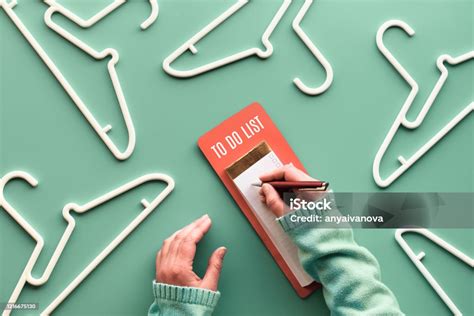 빈 옷걸이 목록을 할 쓰기 여자의 손 코로나바이러스 위기 상품 부족 시 시간 관리 파스텔 그린 민트 배경에 창조적 인 평면 누워