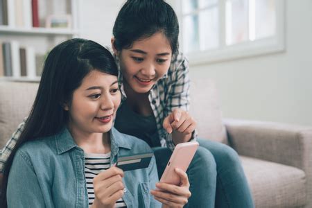 Two Asian Best Friend Sharing One Cellphone Shopping On Internet Stock Image Everypixel