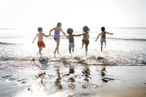 Deux Enfants Courant Sur La Plage Avec Des Ballons De Couleur Image