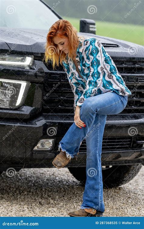A Lovely Red Headed Country Wetern Model Poses Outdoors In A Country