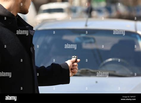 Man Pushing Button On Remote Control Of Car Alarm System Outdoors Stock Photo Alamy