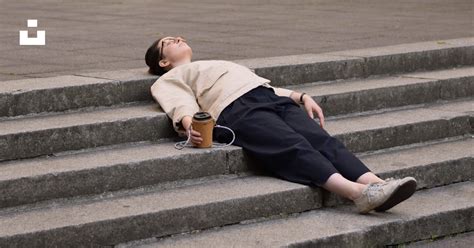 갈색 후드티와 검은색 바지를 입은 남자가 회색 콘크리트 계단에 앉아 있다 사진 Unsplash의 무료 베를린 이미지