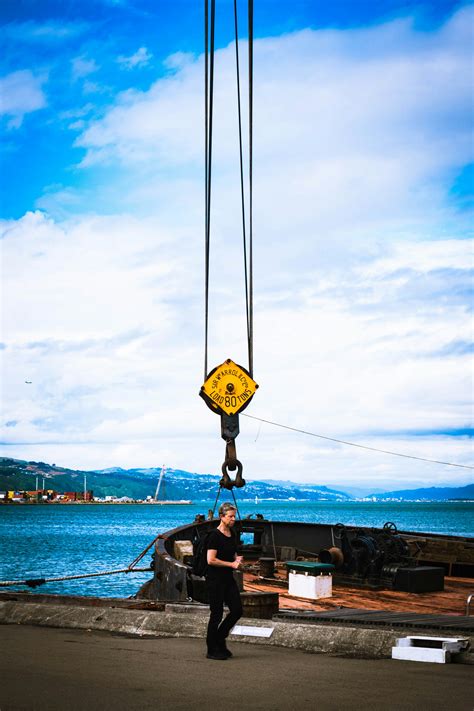 노란색 표지판을 들고 부두에 서 있는 남자 사진 Unsplash의 무료 사람의 이미지