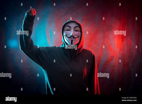 Hacker With Anonymous Mask With His Fist Raised In Symbol Of Fight Red