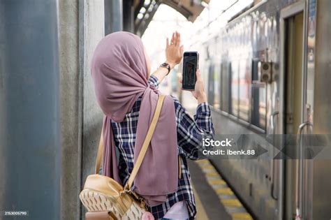 기차역 플랫폼에서 스마트폰을 들고 작별 인사를 하는 아시아 무슬림 여성의 뒷모습 여행 컨셉 30 34세에 대한 스톡 사진 및