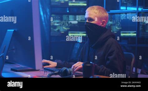 Caucasian Woman Hacker With Blond Short Hair And Masked Face Sitting In