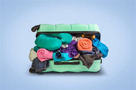 파란색 배경에 넘쳐 나는 바퀴가있는 플라스틱 가방 여행 컨셉 휴가 여행 친척 방문 여행 가방에 대한 스톡 사진 및 기타 이미지