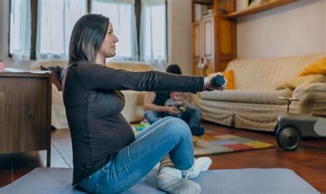 Madre Haciendo Ejercicio Mientras El Padre Juega Con El Hijo En El