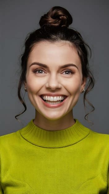 Photo Of Smiling Cute European Woman With Hair Knot Wears Bright Green Sweater Has Broad Smile