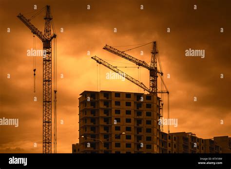 Cranes Work Near Concrete House Carcass With Empty Windows Building Is