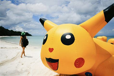 A Woman Walking On A Beach Next To A Large Inflatable Pikachu Photo Free Beautiful Woman Image