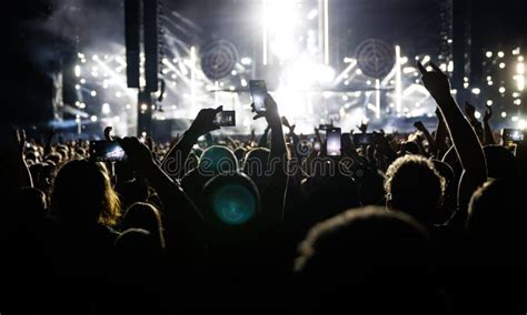 Crowd Of People With Raised Hands At A Live Music Festival Cheering