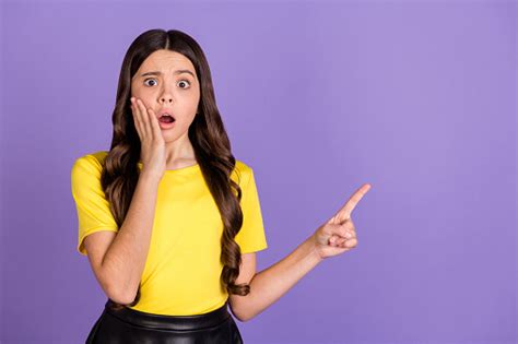 멋진 감동 갈색 머리 머리 소녀 포인트 빈 공간의 초상화는 생생한 라일락 색상 배경에 고립 된 노란색 티셔츠를 착용합니다 T 셔츠에 대한 스톡 사진 및 기타 이미지 Istock