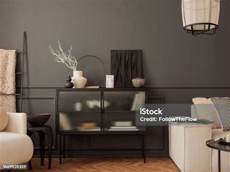 모의 포스터 프레임 유리 사이드 보드 말린 꽃이있는 꽃병 모듈 식 소파 나무 바닥 어두운 벽 및 개인 액세서리가있는 거실 인테리어의 창의적인 구성 가정 장식 템플렛 0명에