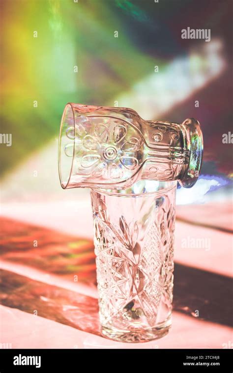 Faceted Glasses Cast A Shadow On A Multicolored Rainbow Background