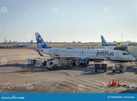 Jetblue Company Airplane On The Runway With Ground Support Equipment
