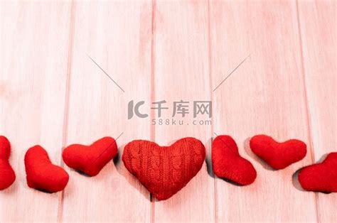 在活珊瑚色木桌上为情人节准备的一组光面工艺红心文胸玫瑰花瓣高清摄影大图 千库网